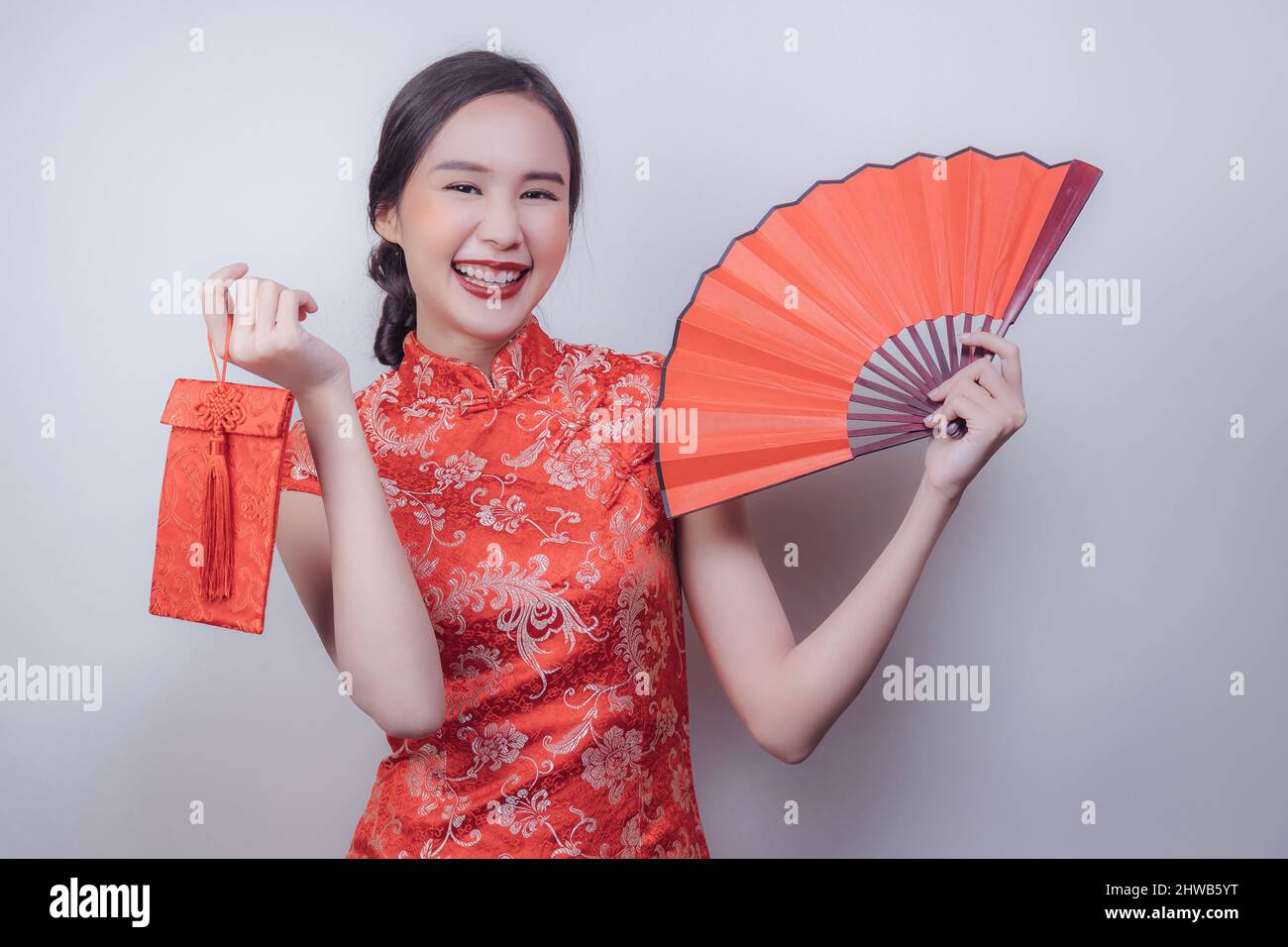 Asian woman in national dress of Chinese new year holding red ang pao ...
