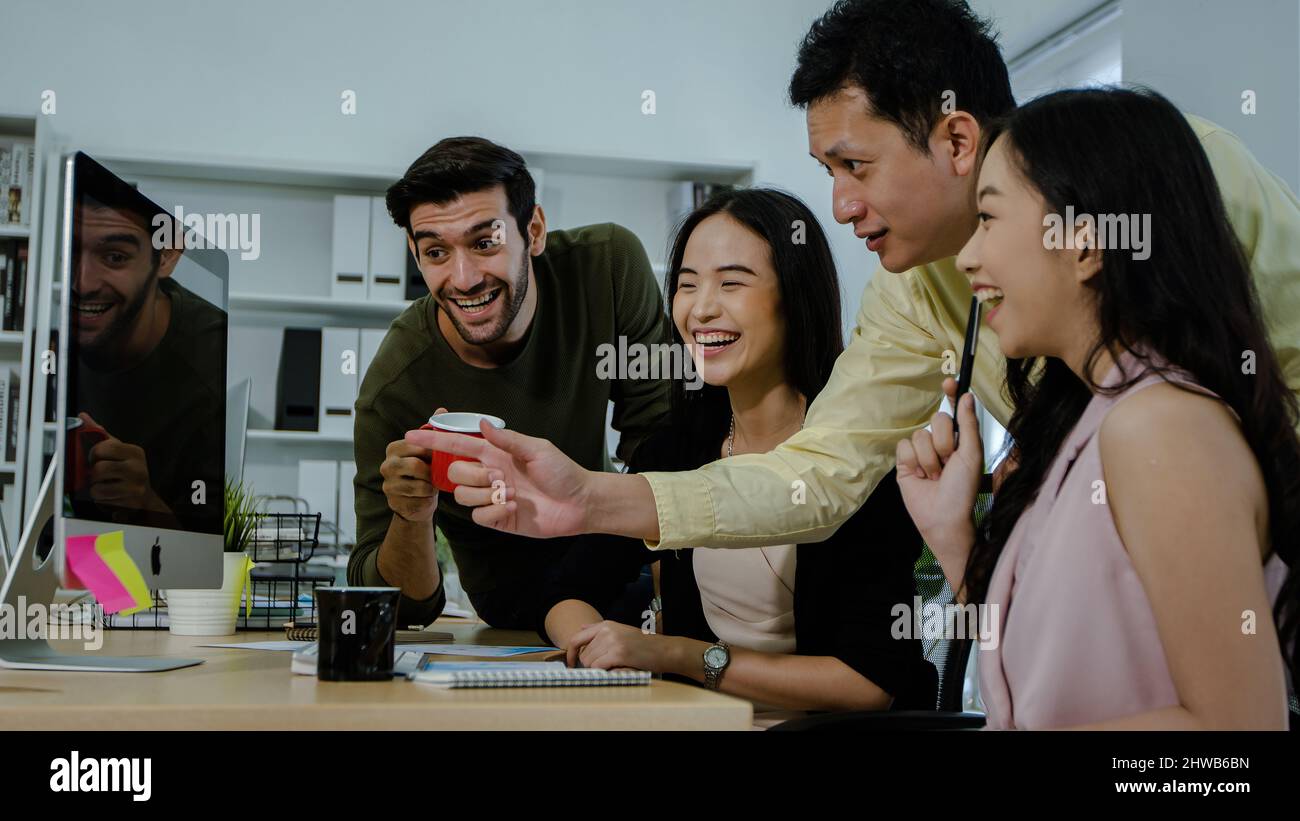 happy business team people working in office looking at monitor ...