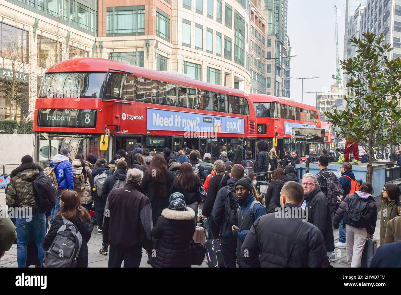 London, UK. 3rd March 2022. A large crowd of people wait at a bus stop ...