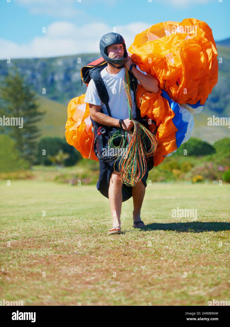 Ready for action. Shot of a man carrying his paragliding equipment ...