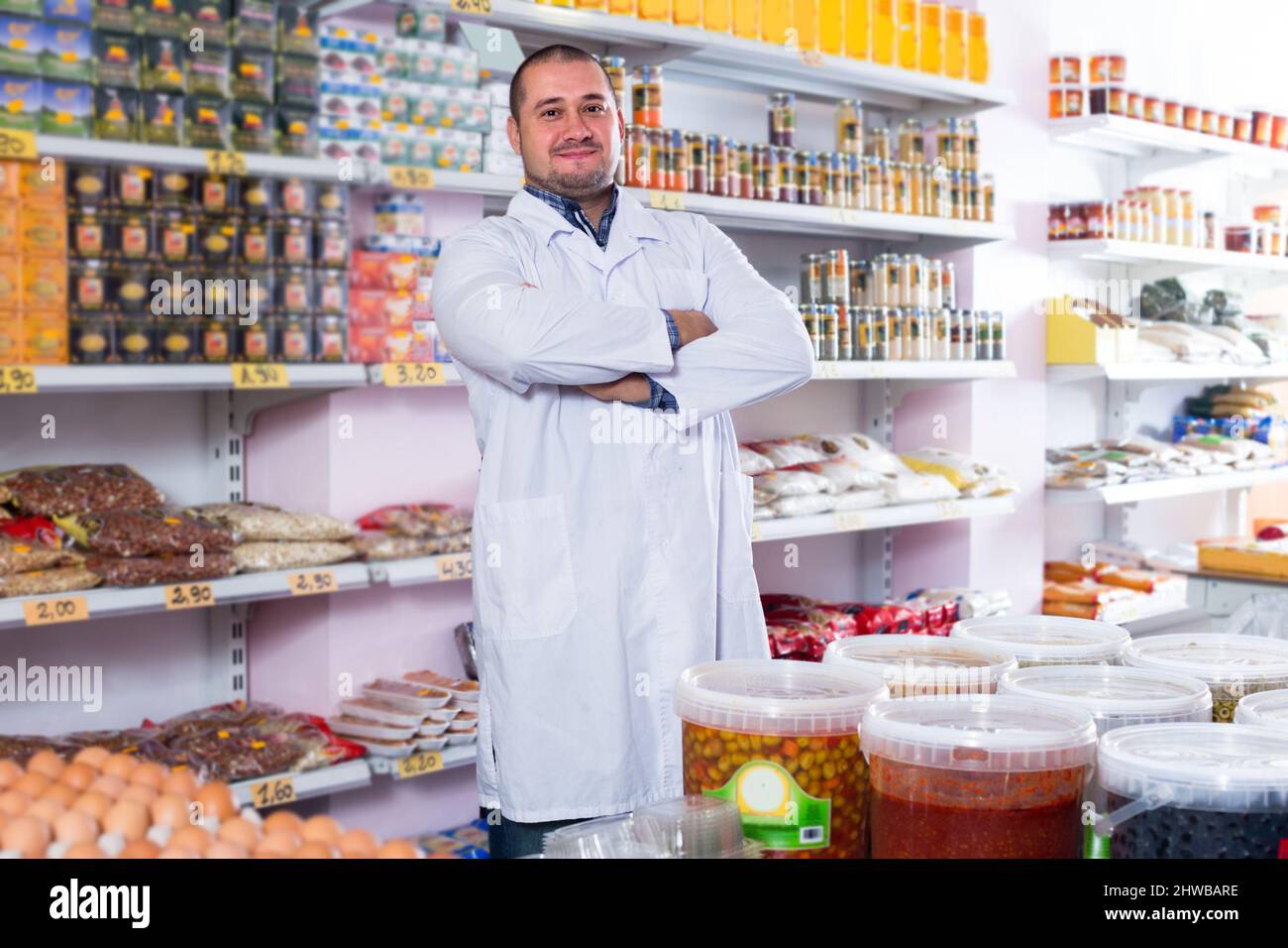happy salesman offering salted olives with filling in ordinary food ...