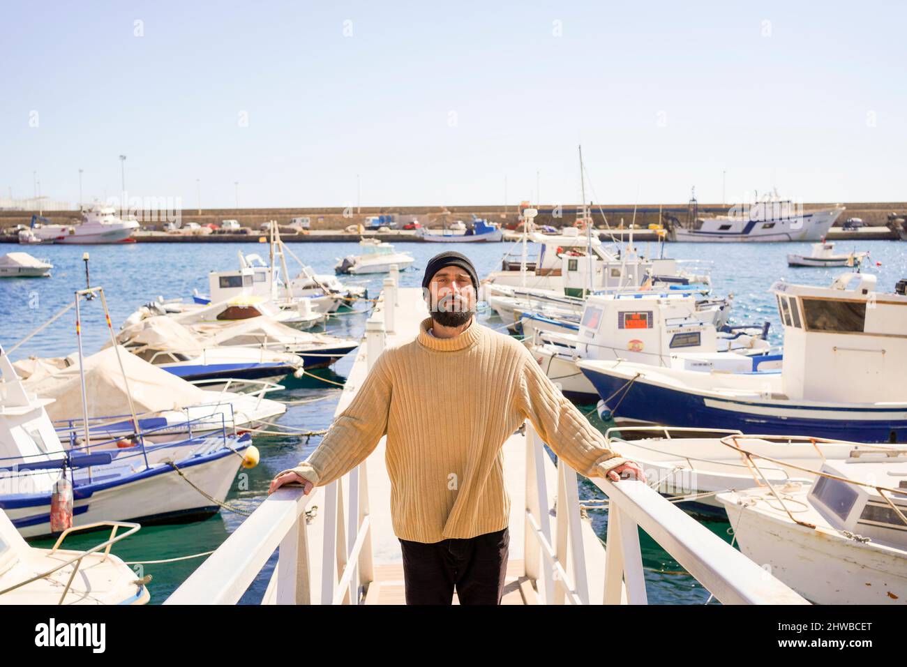 Tall and robust young sailor man with a beard in a woolen cap and high ...