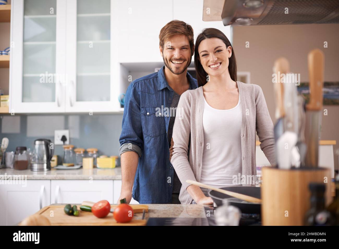 Bonding over date night. A young couple making dinner together at home ...