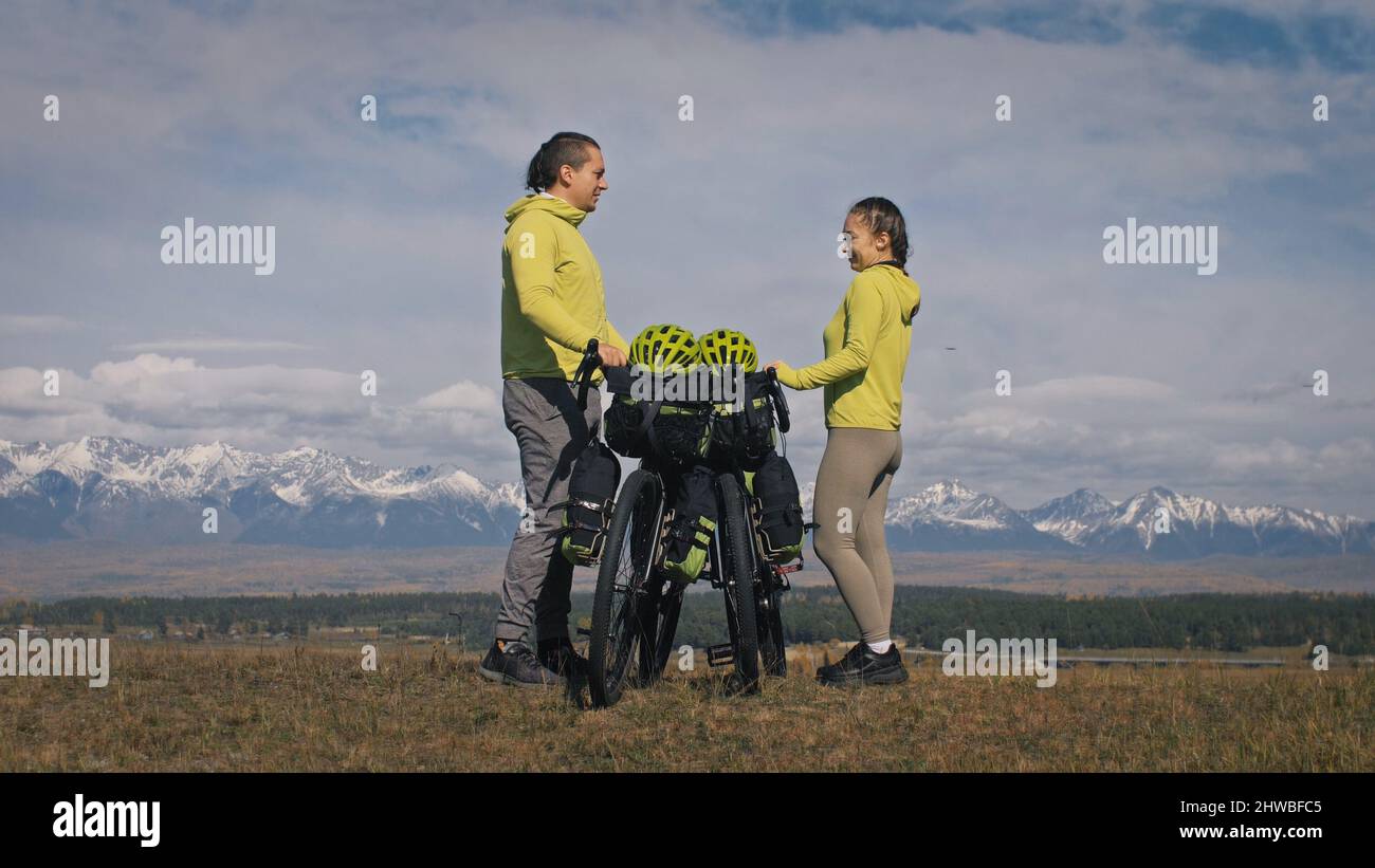 The man and woman travel on mixed terrain cycle touring with ...