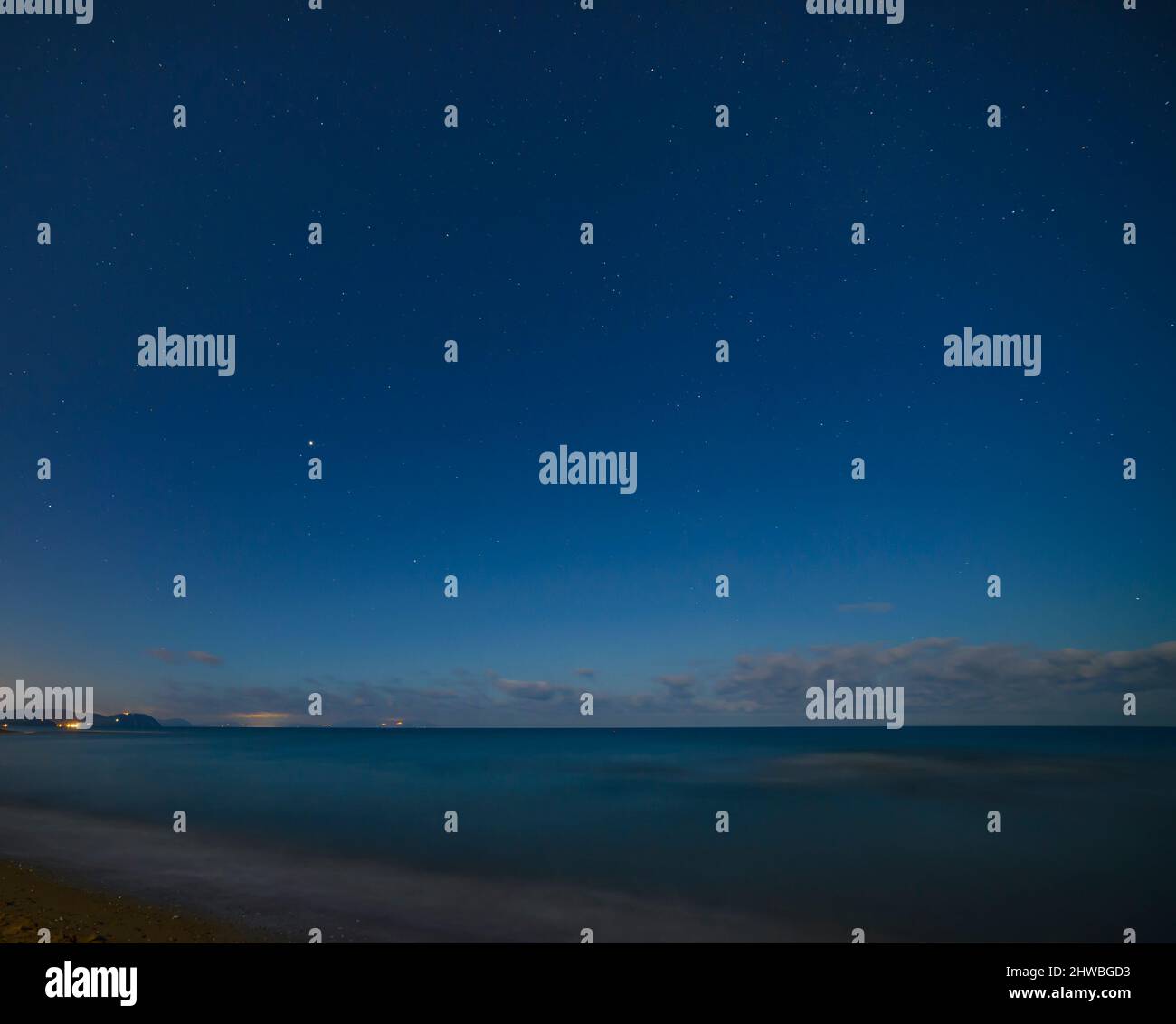 Night seascape with bright sky, milky way, sea with waves and sand ...