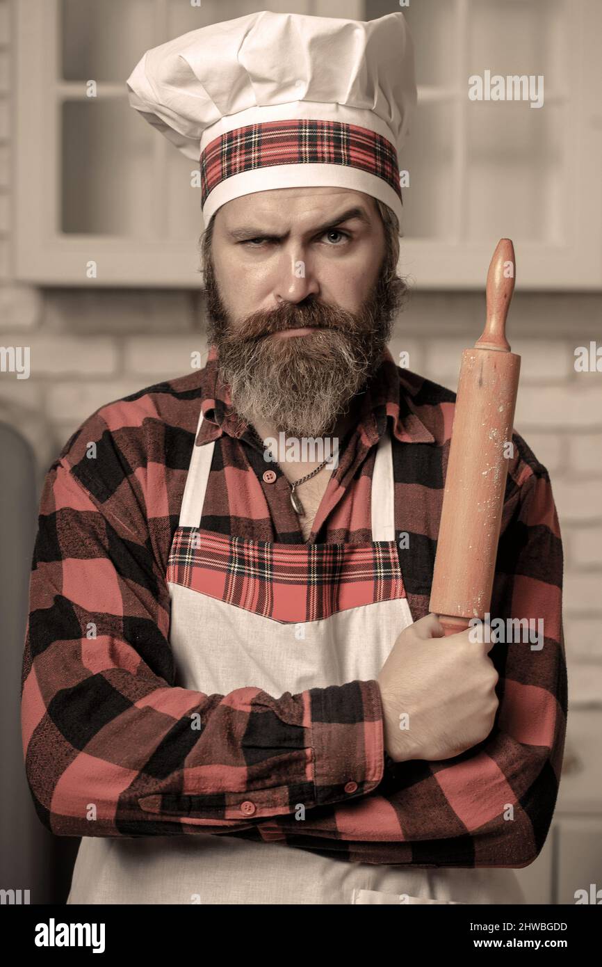 Brutal bearded chef cook in white uniform standing with crossed arms in ...