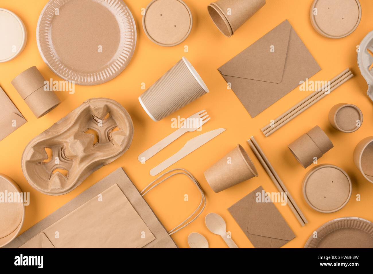 Eco-friendly tableware - kraft paper utensils on yellow or orange ...