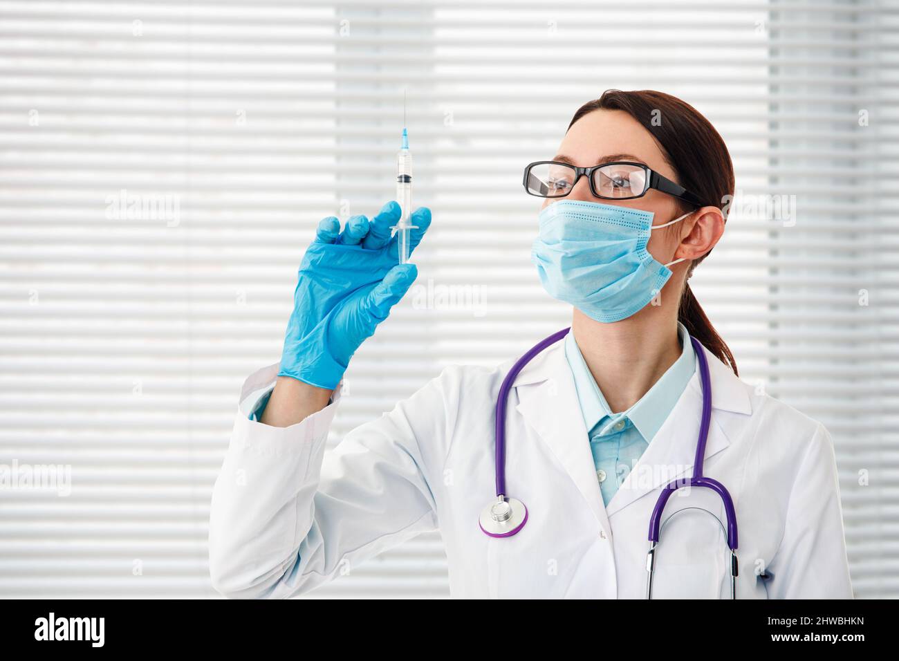 A nurse holds a syringe before giving an injection. The concept of ...
