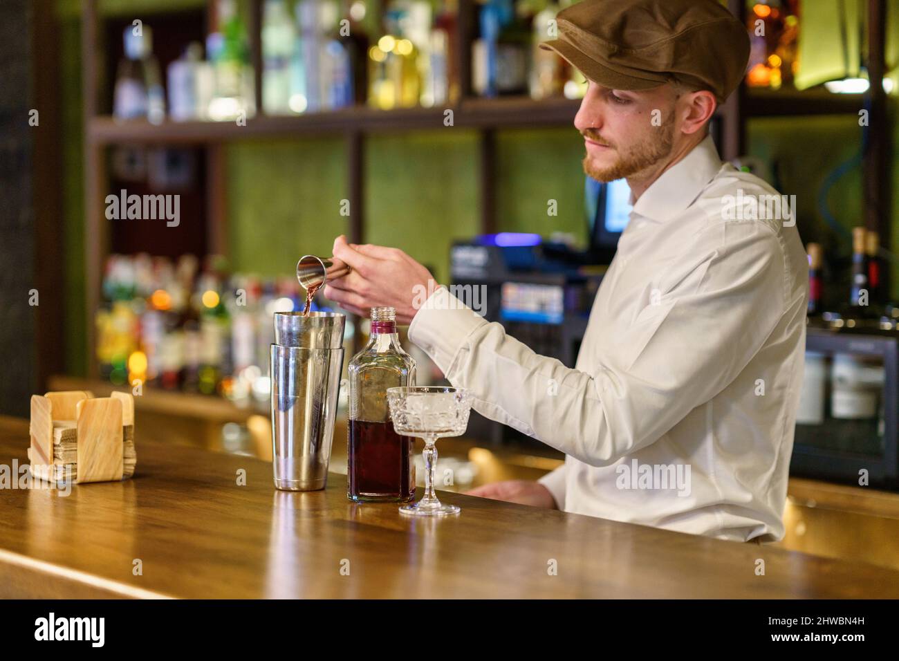 Male barkeeper pouring alcohol into shaker Stock Photo - Alamy