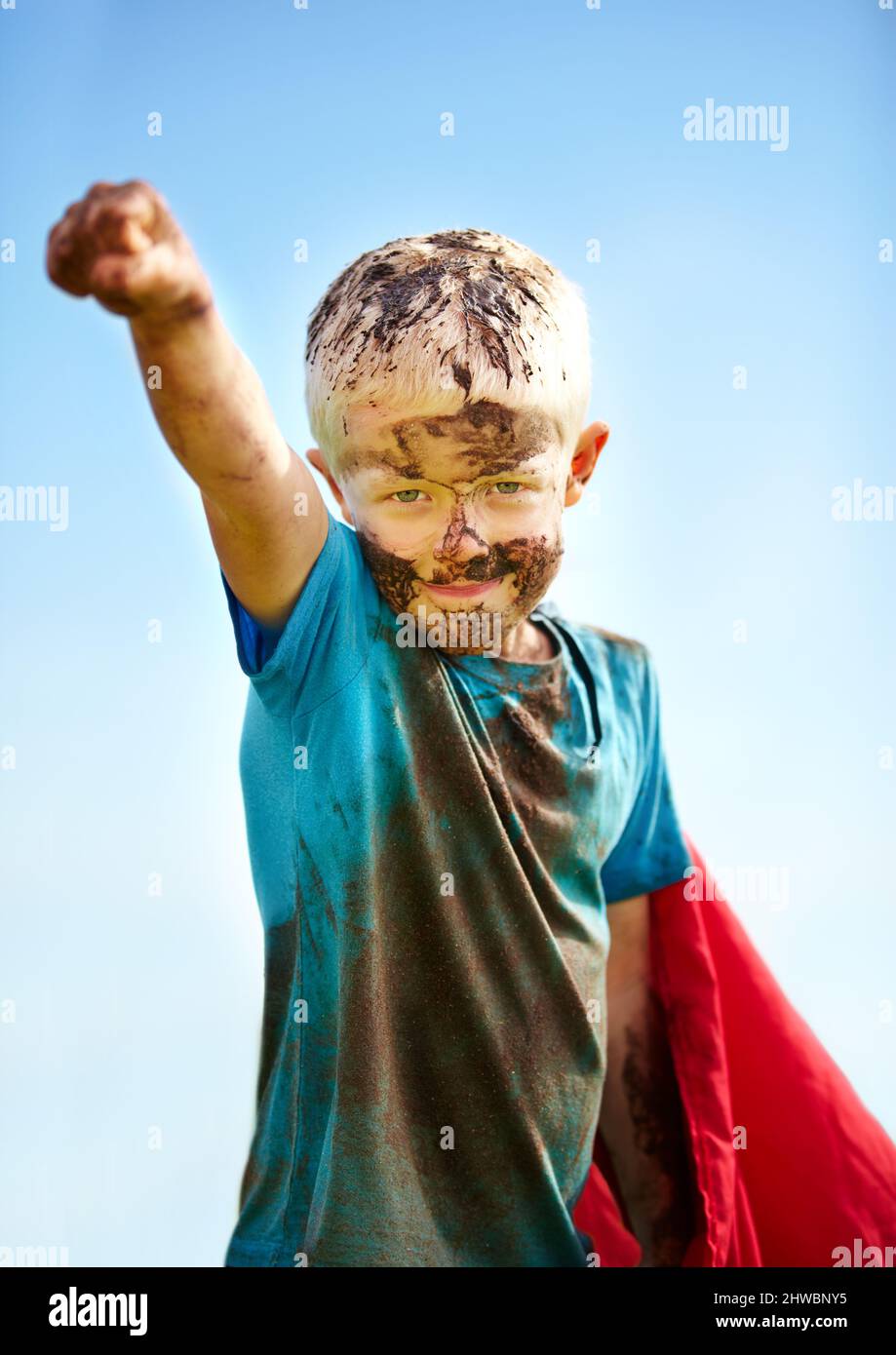 A muddy superhero. A little boy dressed as a superhero and covered in ...