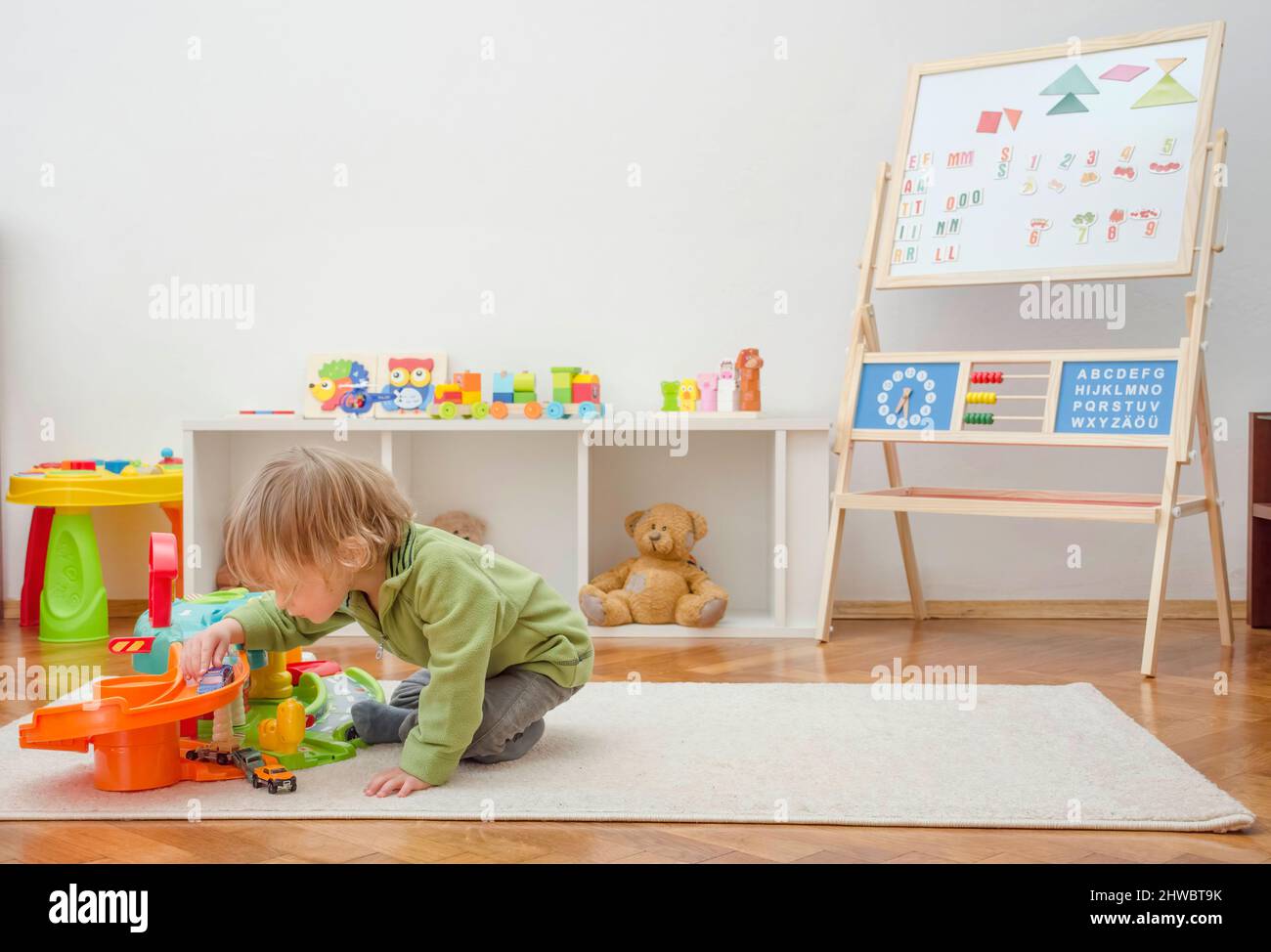 Sweet happy child boy having fun playing with cars and many colorful ...