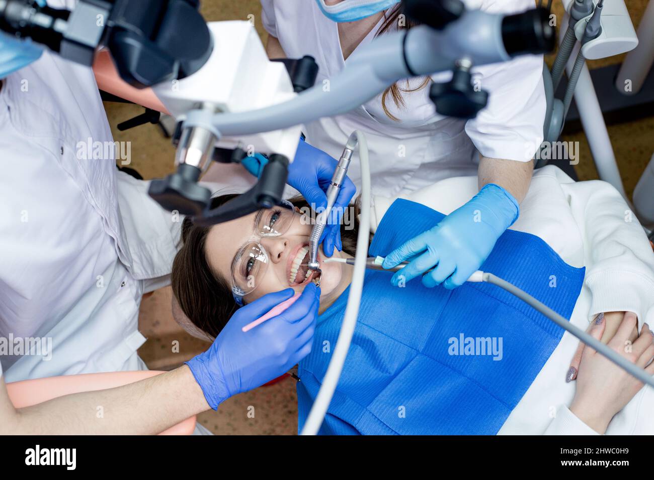 Dentist looking through a microscope at the patient's teeth. Modern ...