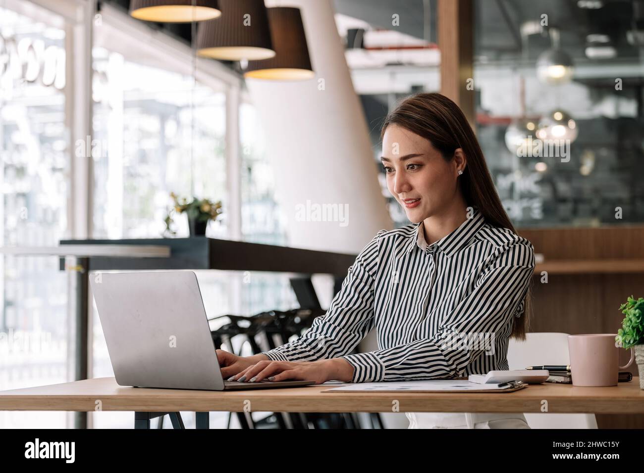 Attractive asian woman using laptop while doing homework making video ...