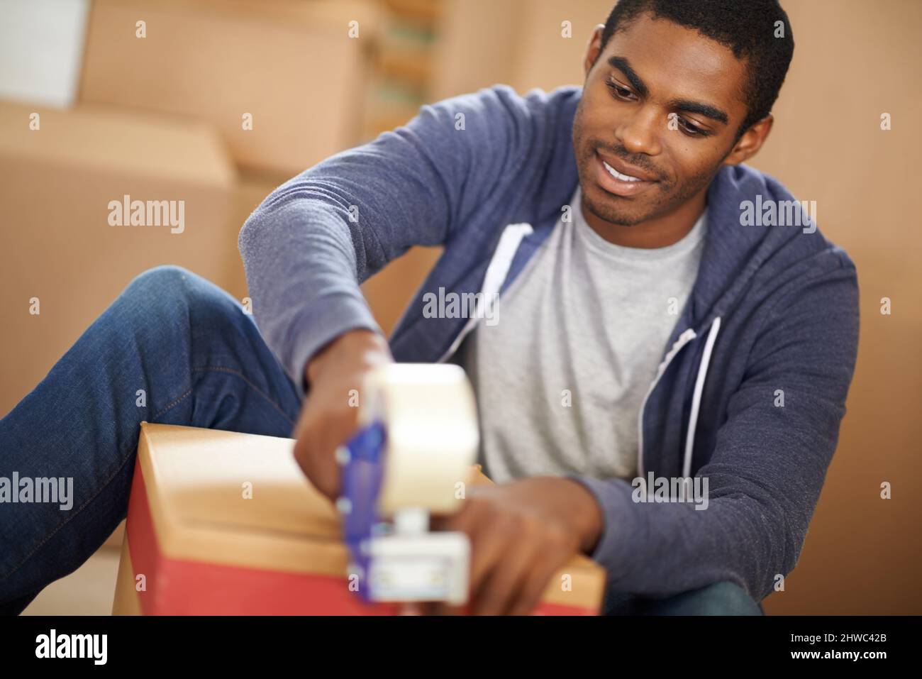 Hes moving house. A handsome young man packing boxes Stock Photo - Alamy