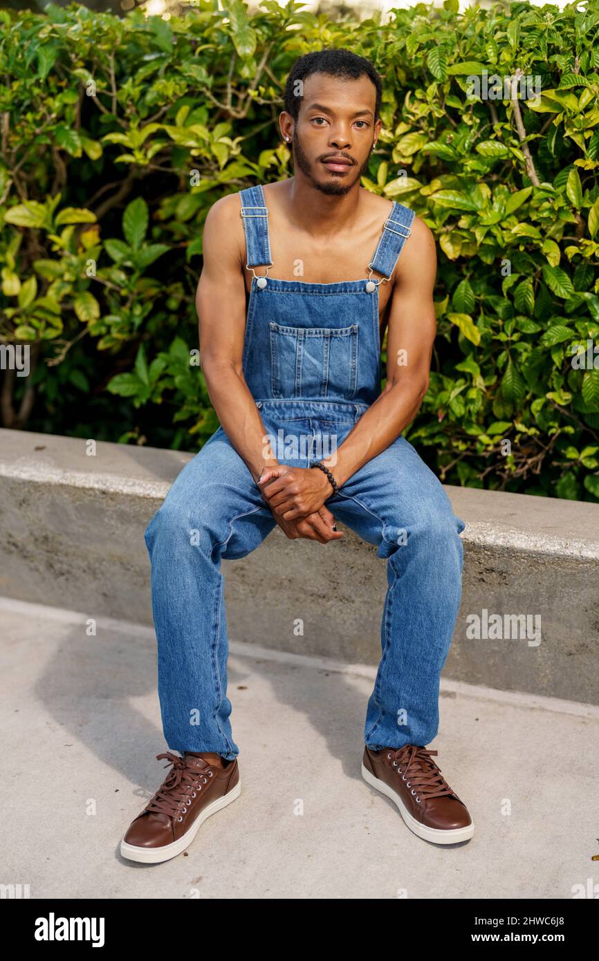 Handsome African American man posing in overalls at a park scene Stock ...
