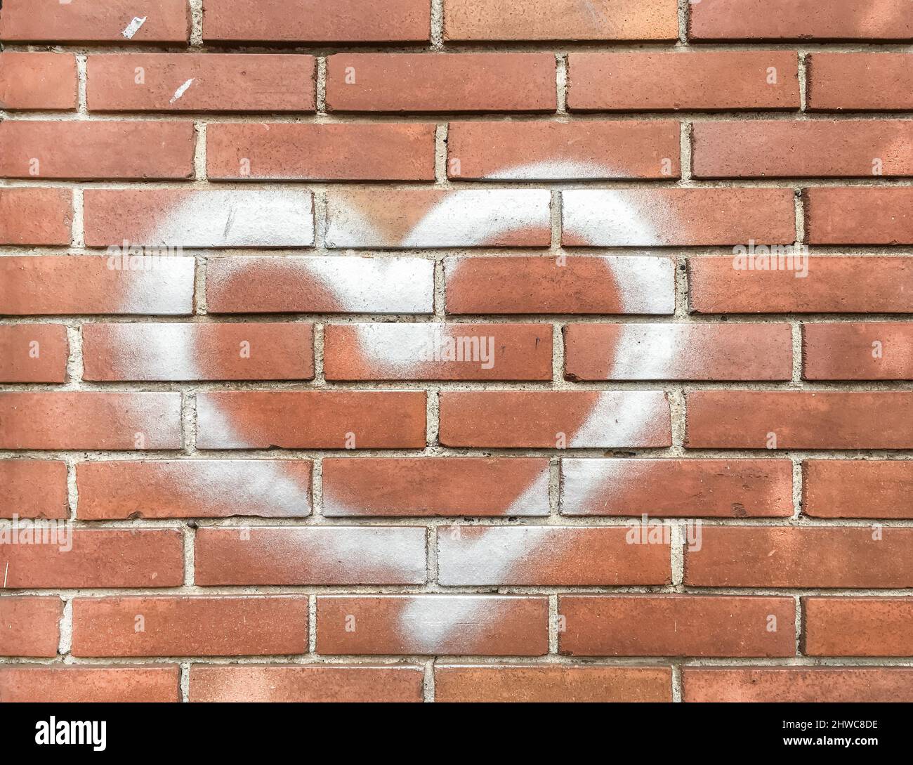 White heart painted on red brick wall. Love concept Stock Photo - Alamy