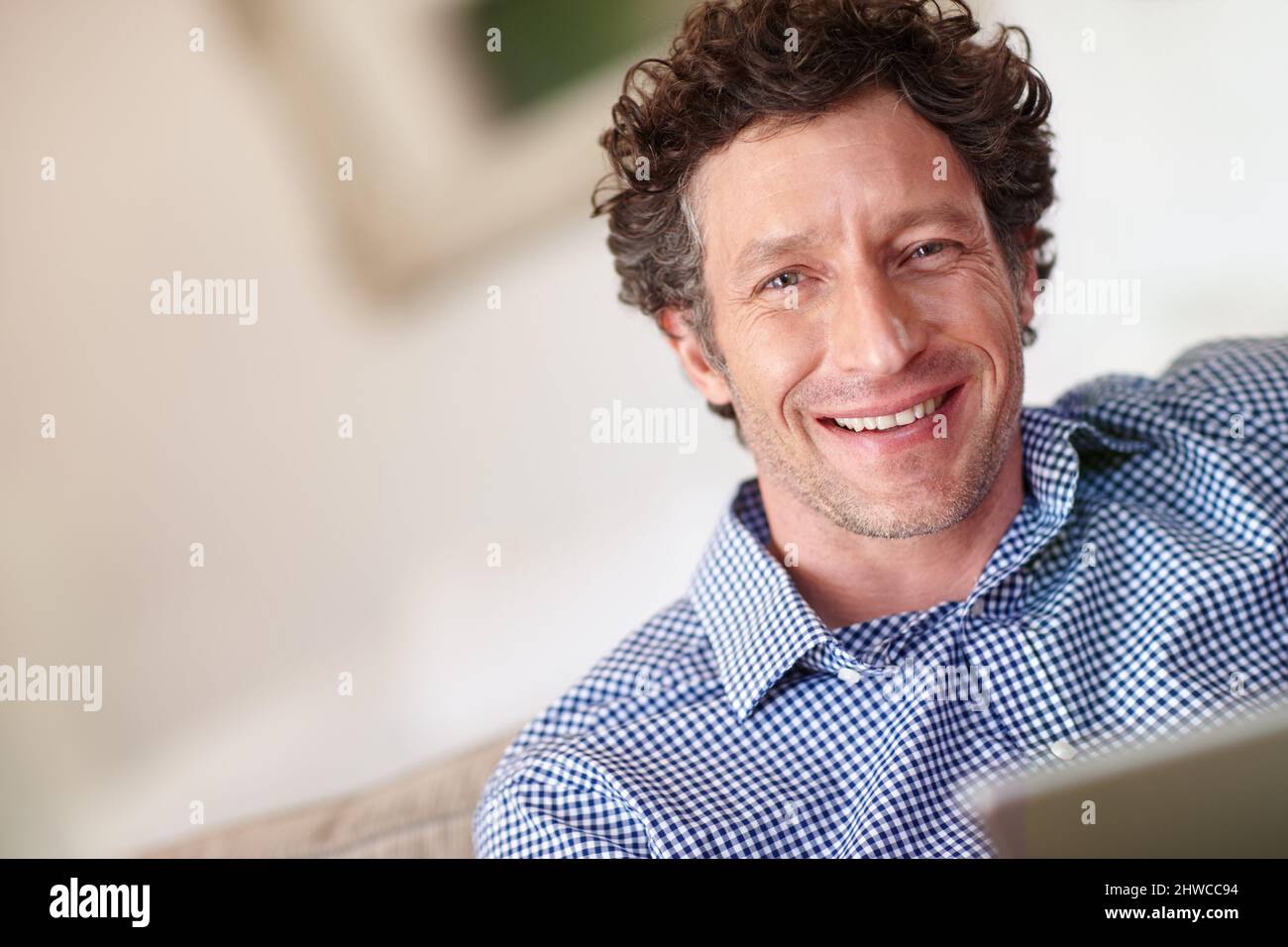Enjoying the comforts of home. Cropped portrait of a happy man using ...