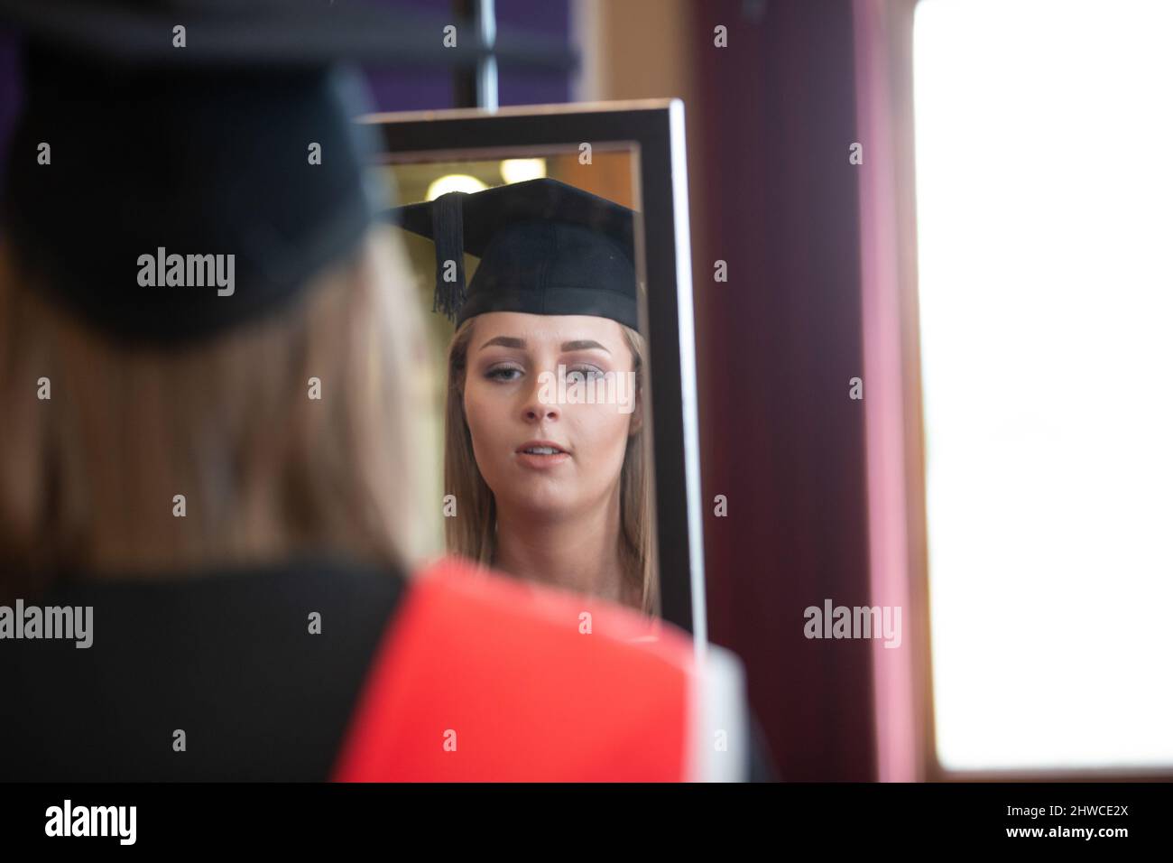 A European female Graduate getting ready for the official photographer ...