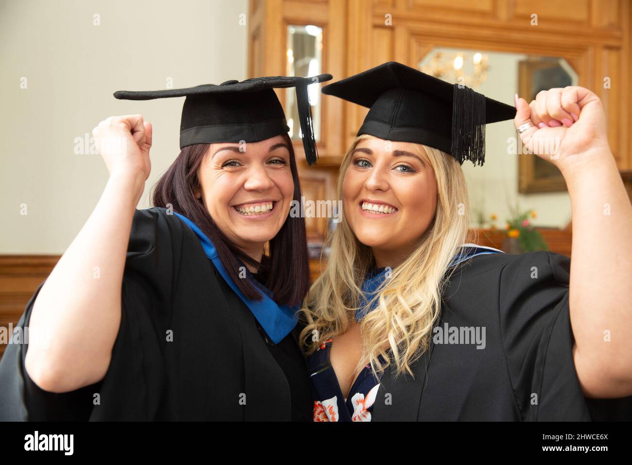 A two female European Graduates getting their gowns and celebrating at ...