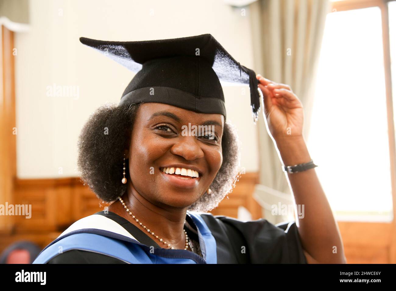 A pretty Afro-Caribbean female graduate at her graduation day ceremony ...