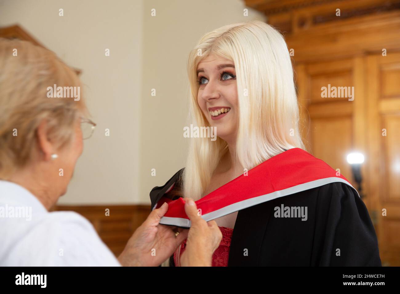 A female European Graduate getting her hood fitted at her graduation ...