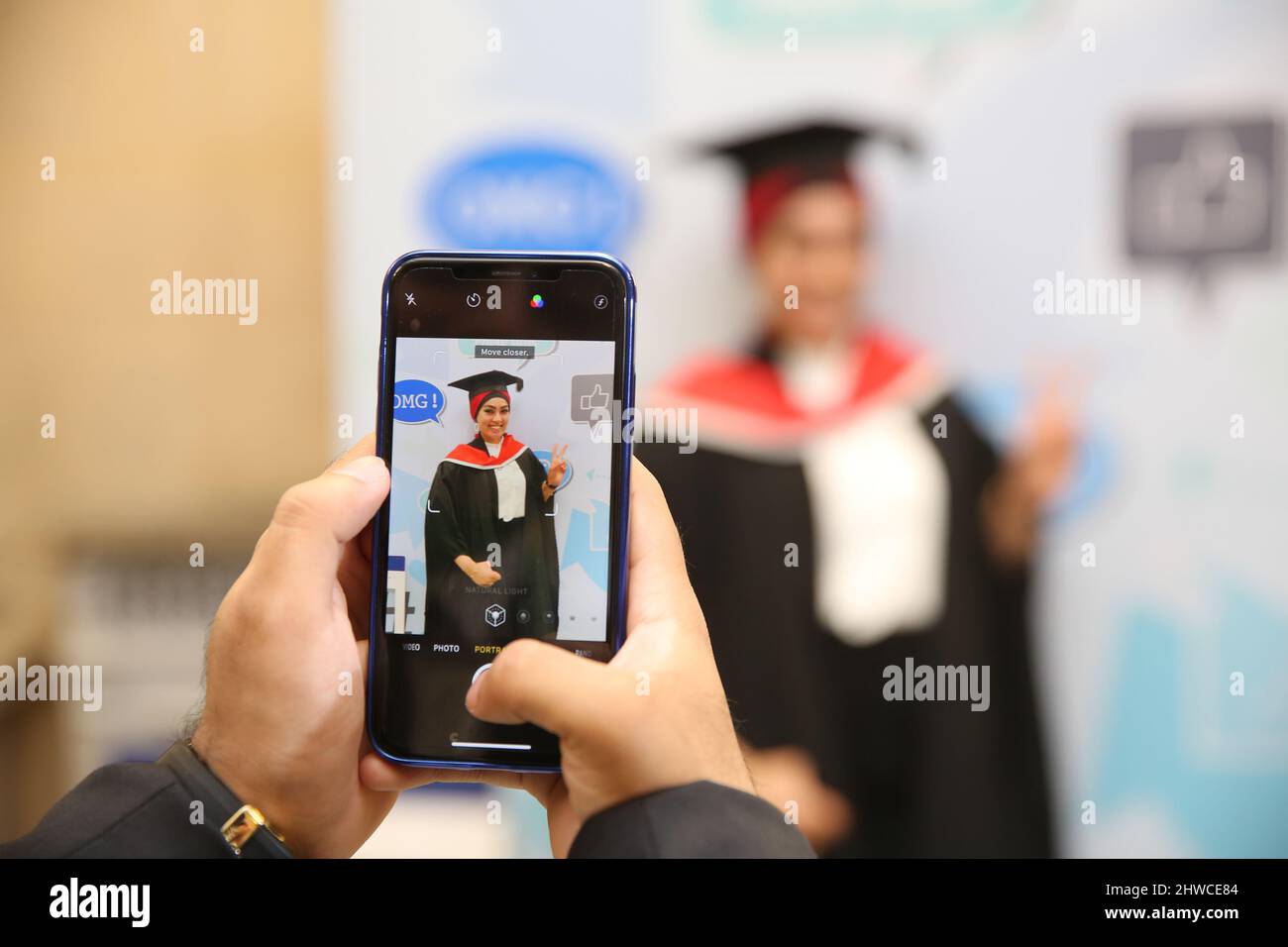 A pretty Asian female graduate poses for a family photograph at her ...