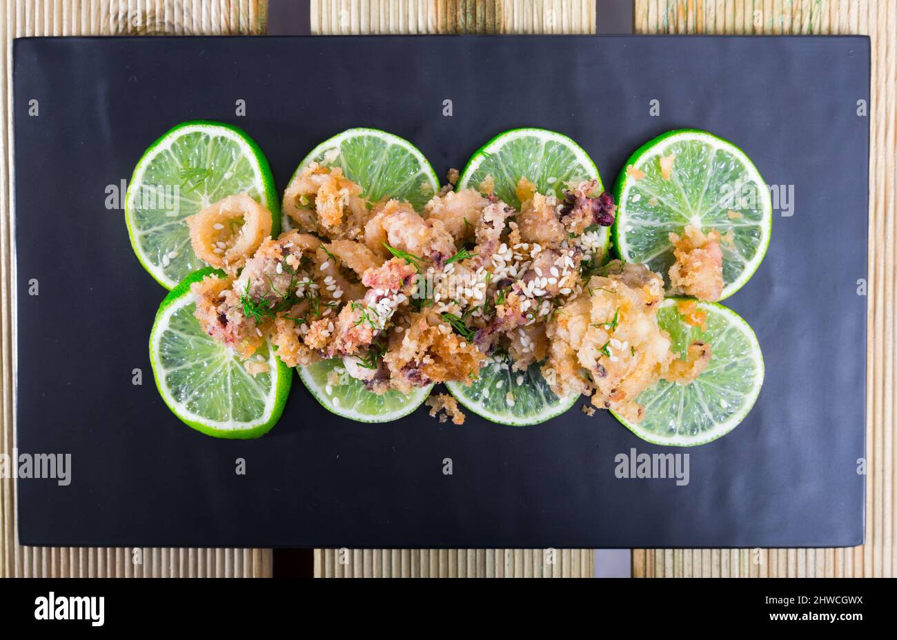Top view of squid and cuttlefish tempura with sliced pickled lime on ...