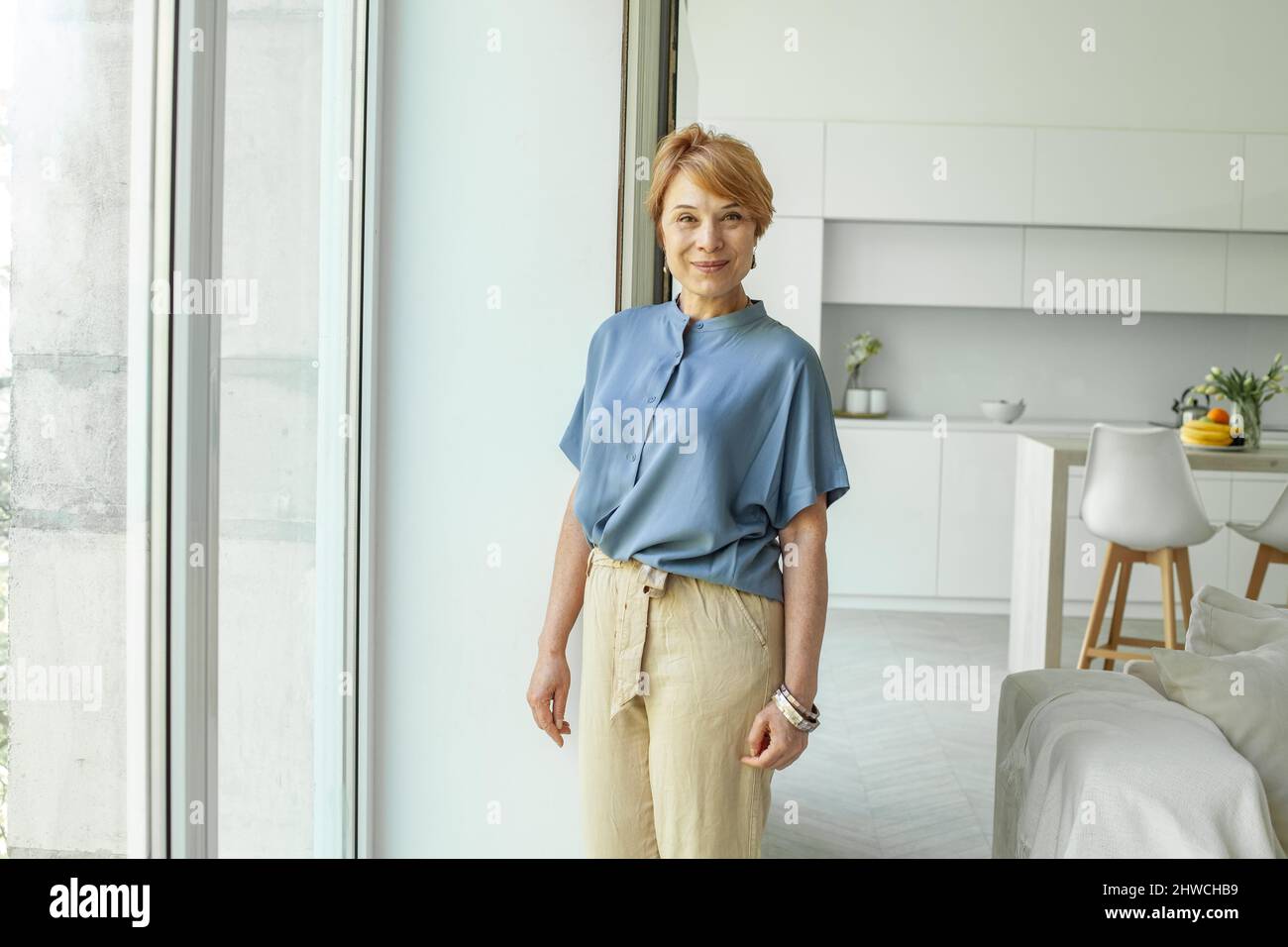 Happy senior woman standing indoor Stock Photo - Alamy