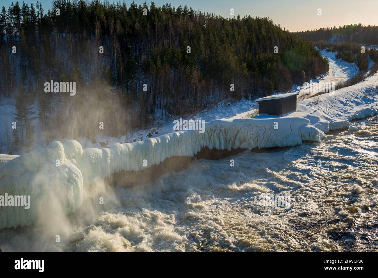 Thick ice is builds up when spillway of a hydroelectric plant is open ...