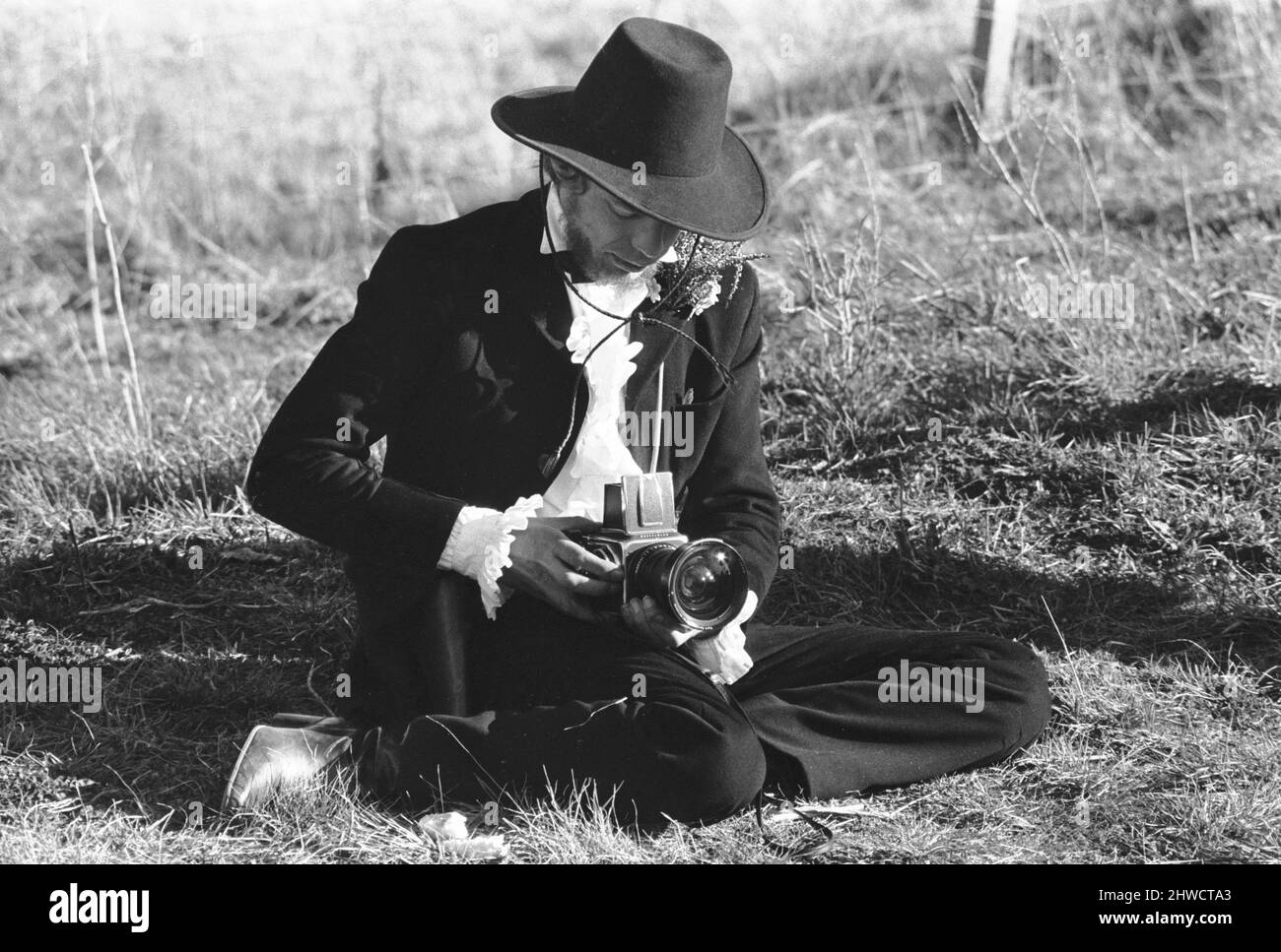 Rolling Stones: Mick Jagger taking pictures with his camera as he sits ...