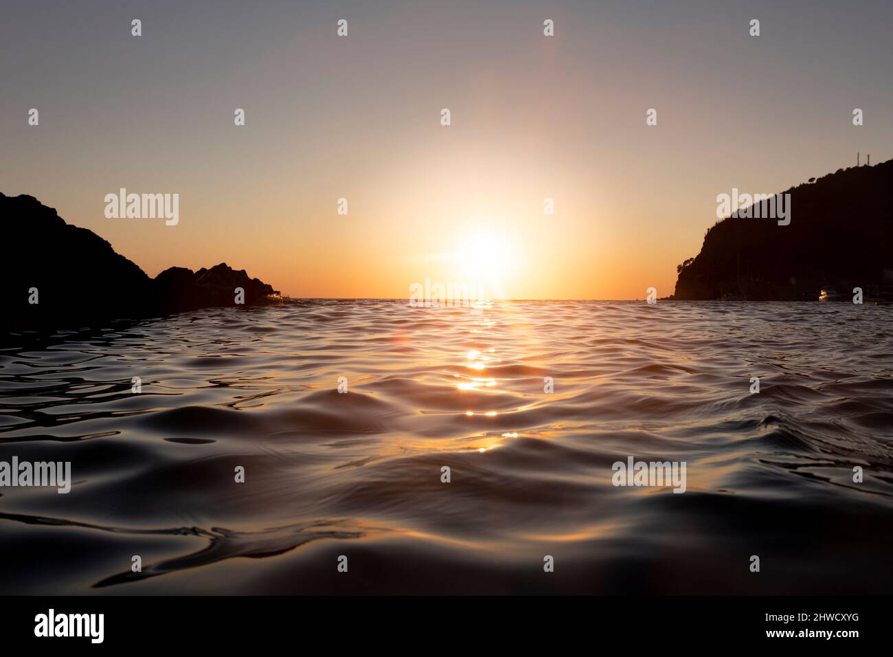 Sunset with yellow sun at the horizon at sea Stock Photo - Alamy