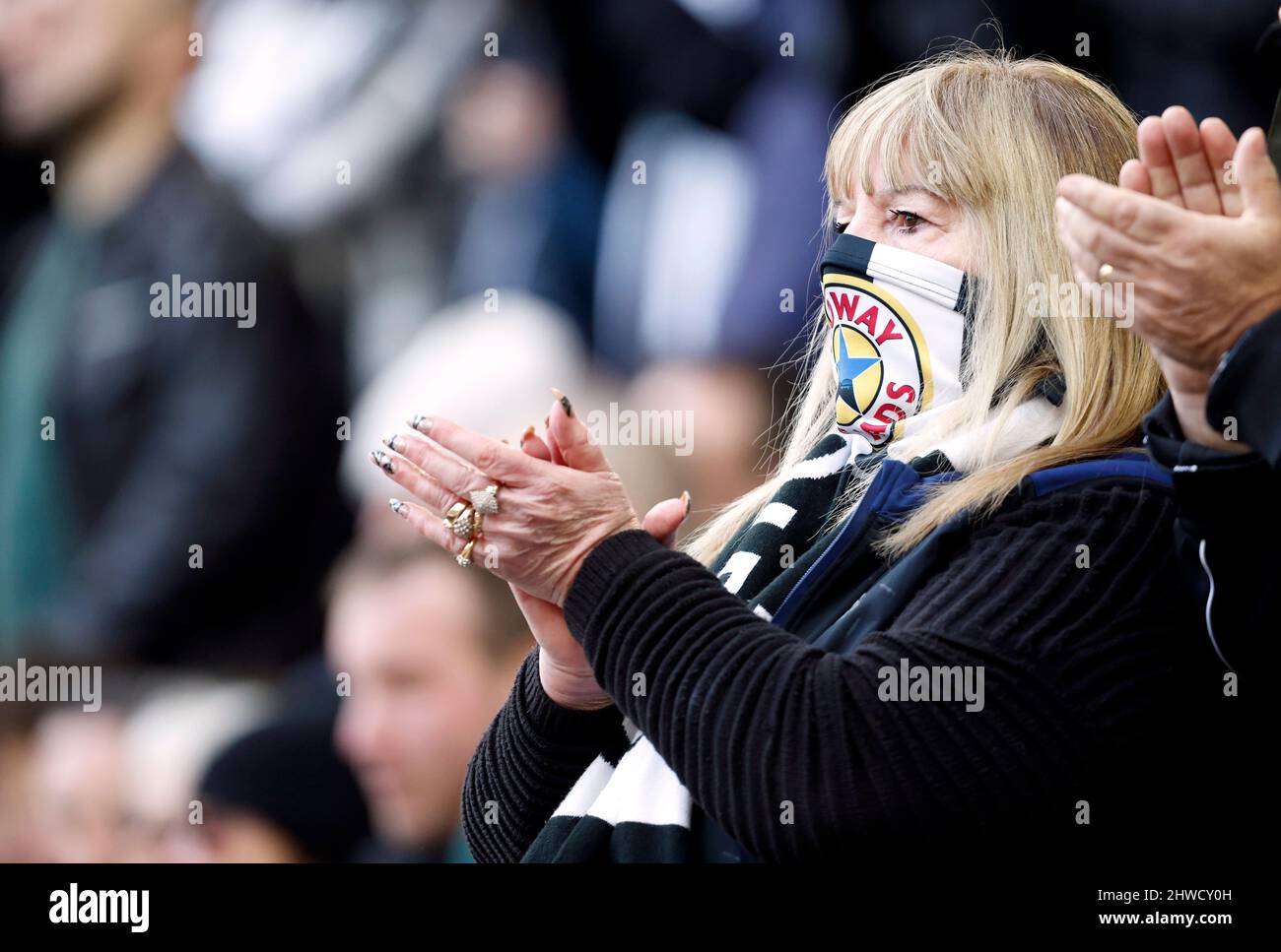 A Newcastle United fan in the stands wearing a face mask during the ...
