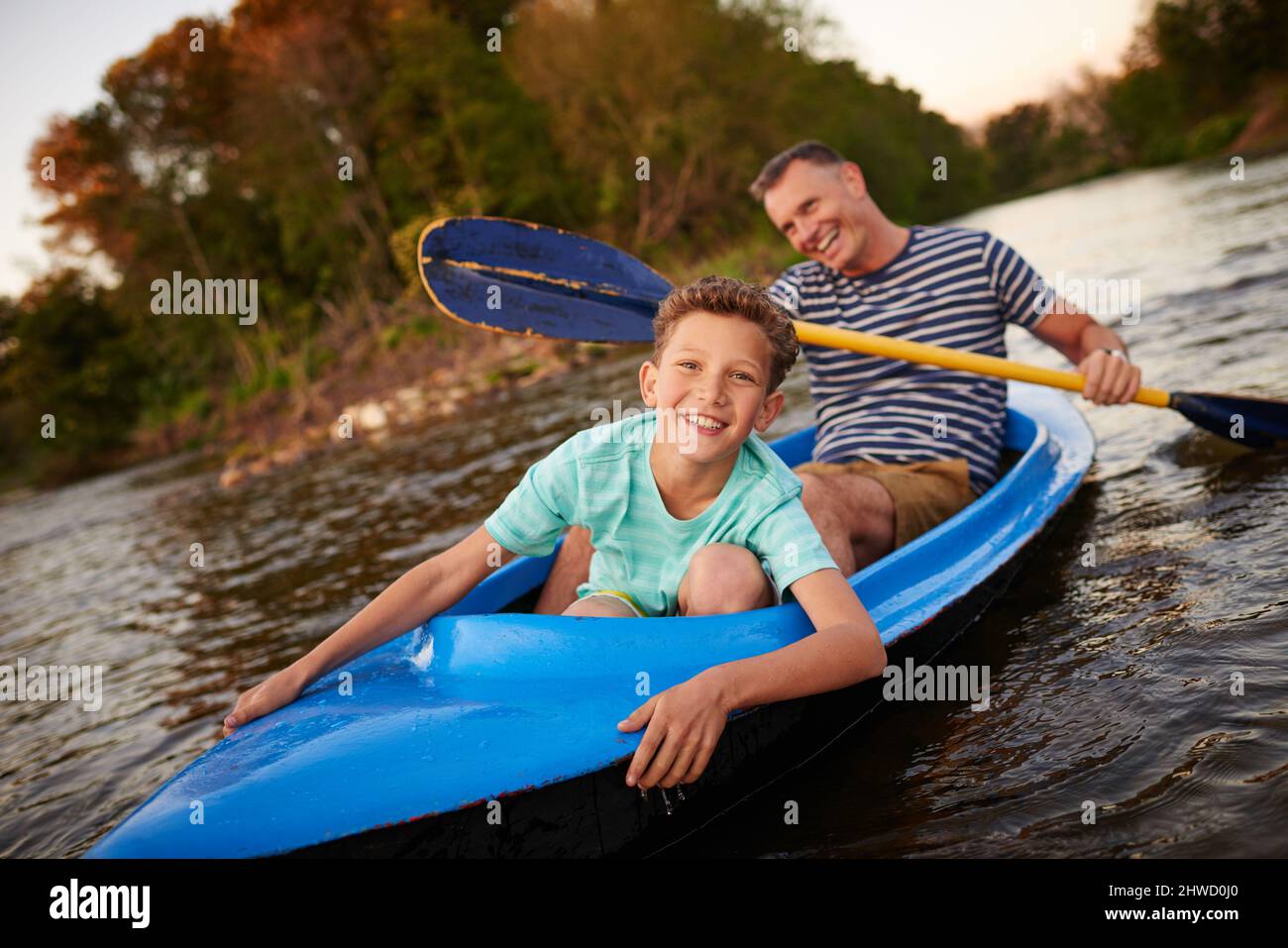 Hes an adventurous little guy. Shot of a father and son rowing a boat ...