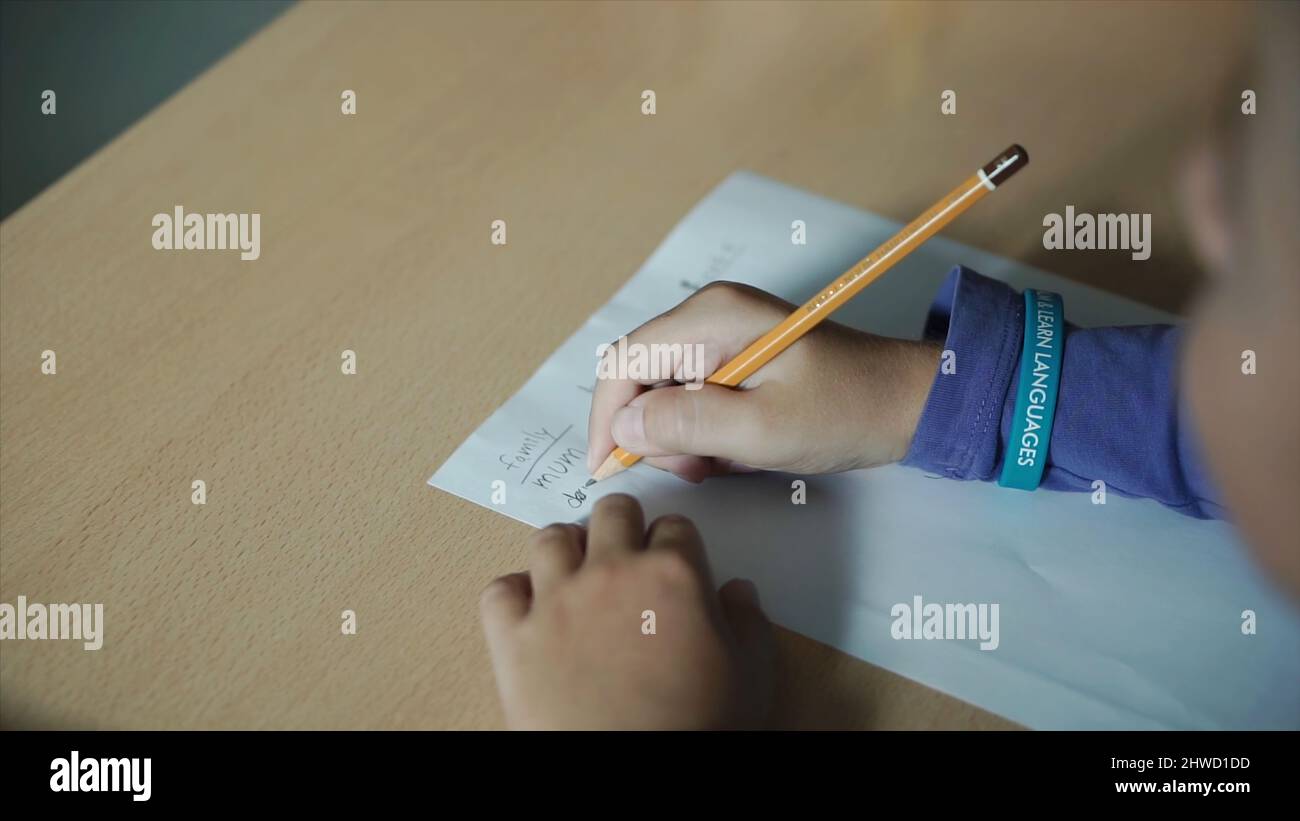 A cute little boy writing with a pencil close up. Clip. Little boy is ...