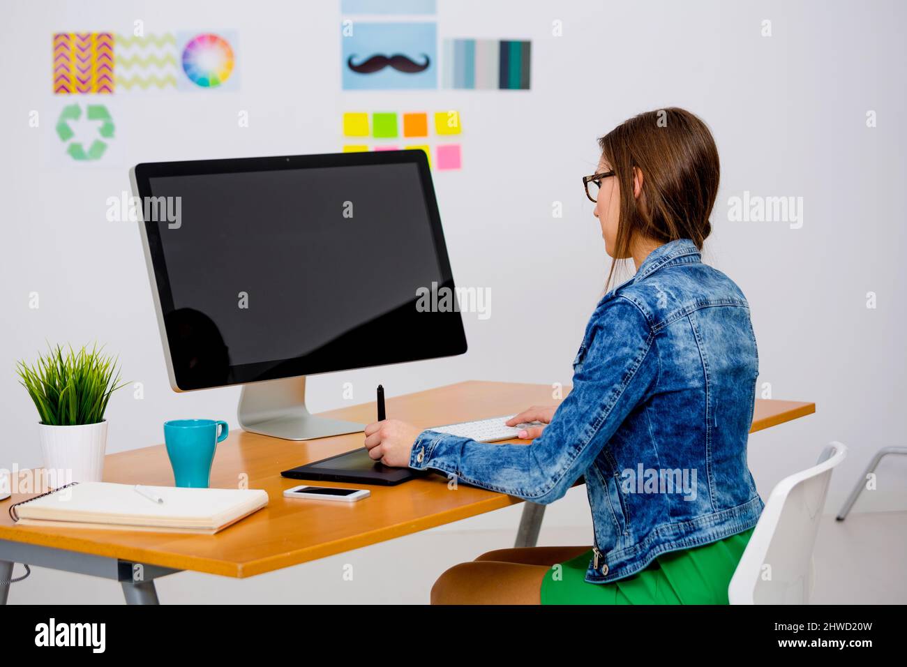 Woman working at desk In a creative office, using a computer Stock ...