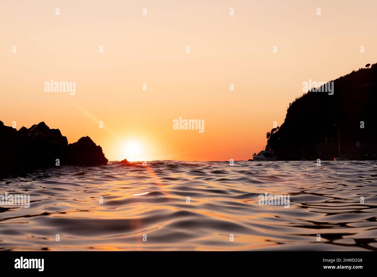 Sunset with yellow sun at the horizon at sea Stock Photo - Alamy