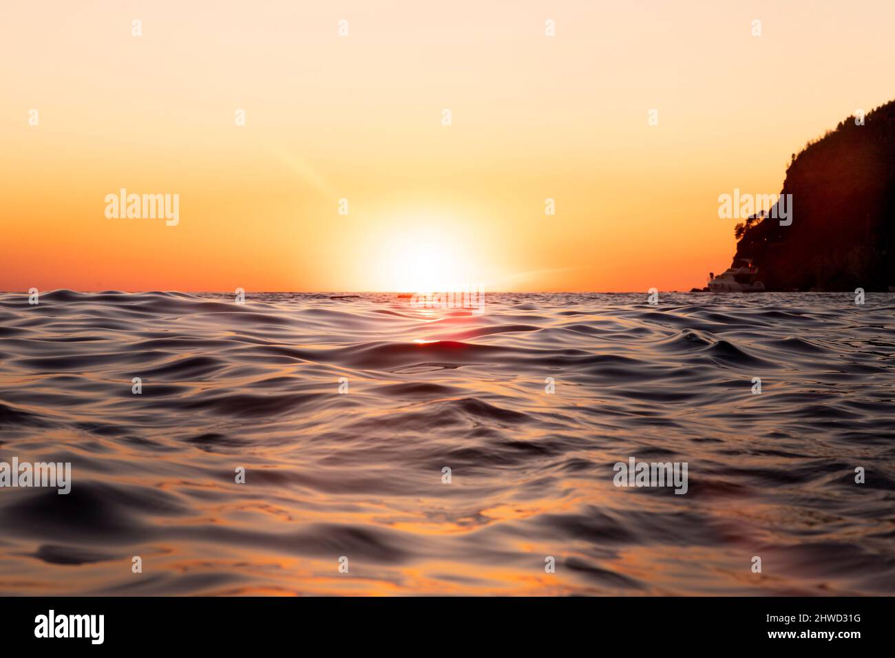 Sunset with yellow sun at the horizon at sea Stock Photo - Alamy
