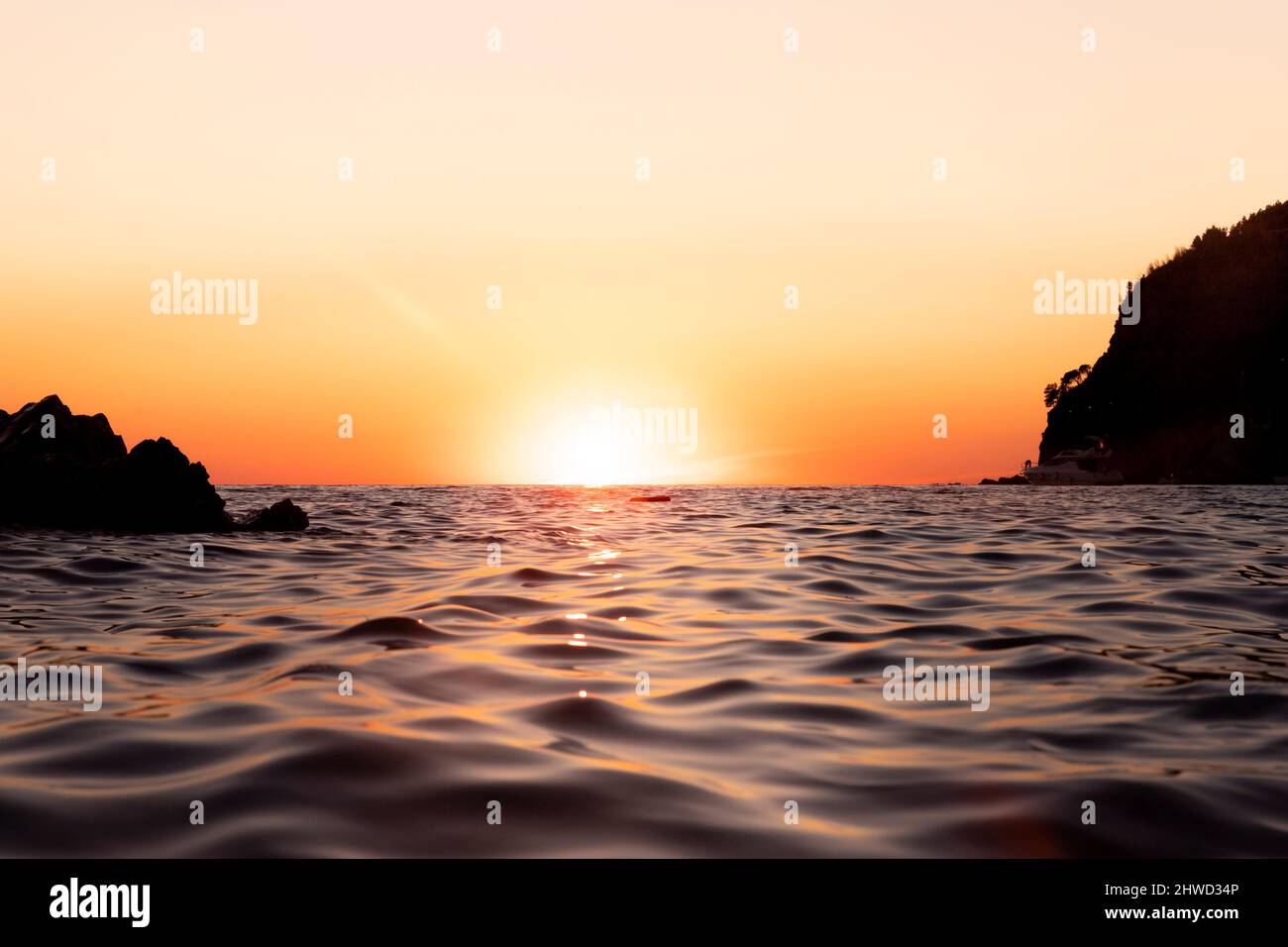 Sunset with yellow sun at the horizon at sea Stock Photo - Alamy