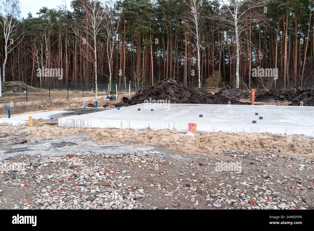 Poured concrete foundation plate made of reinforcing bars, sewer pipes ...