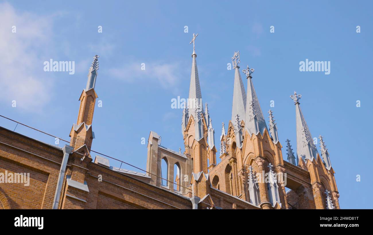 Red brick Gothic Church on background blue sky. Action. Bottom view of ...