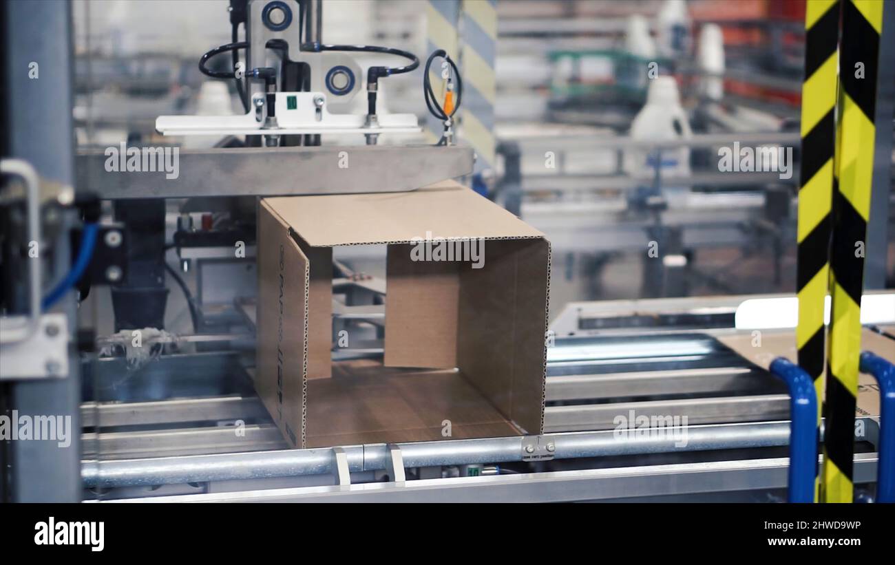 Cardboard package box packing machine. Clip. Box forming production ...