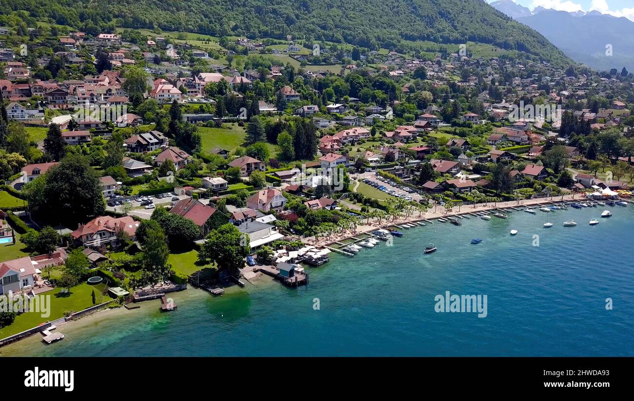 Cottage town on background of mountain and blue lake. Action. Top view ...