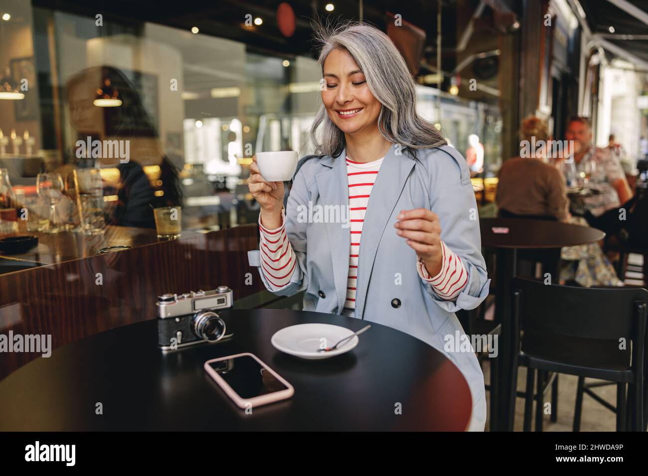 Modern lady sitting with coffee at urban cafe Stock Photo - Alamy