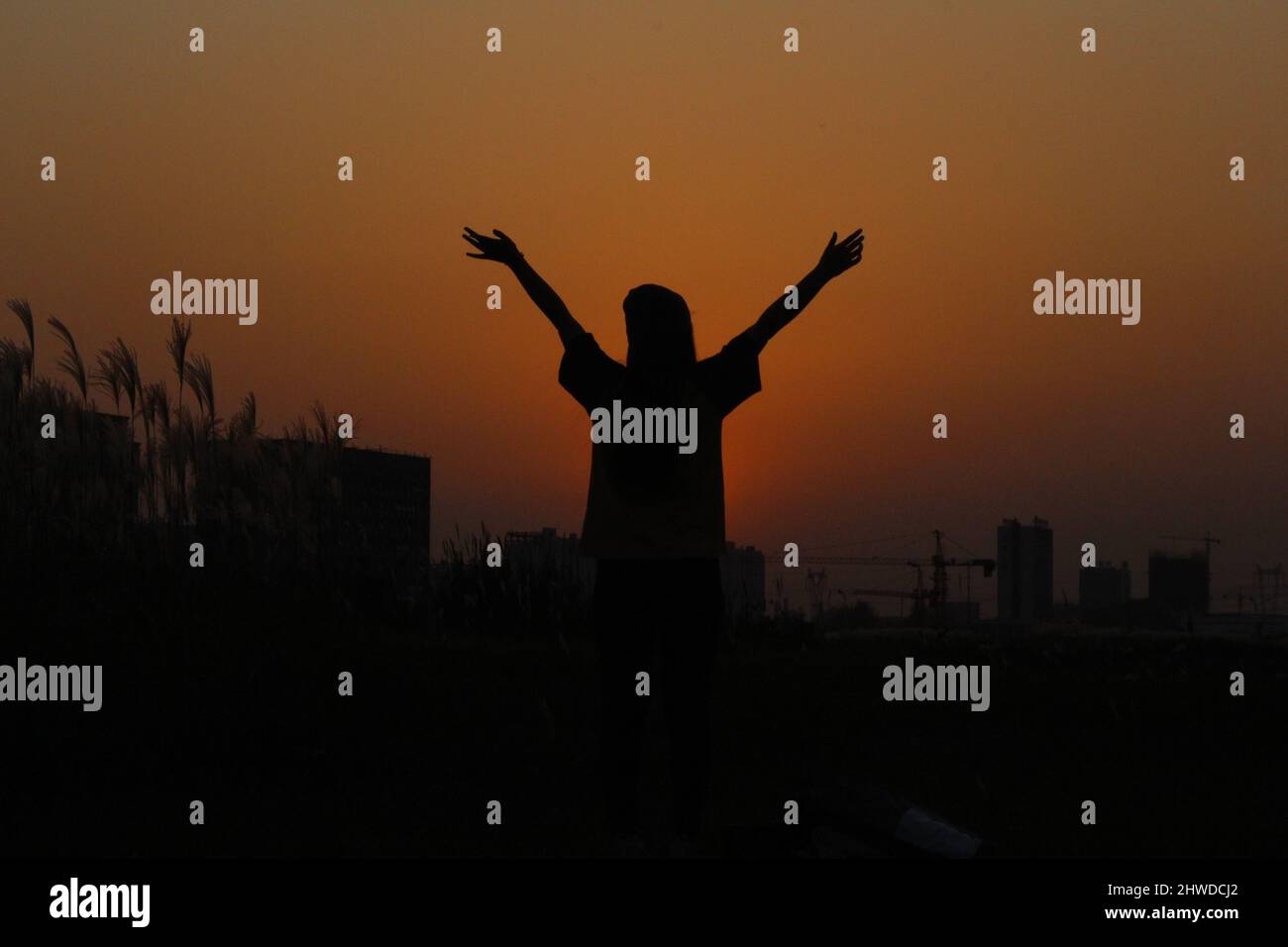 alone woman in sun set Stock Photo - Alamy