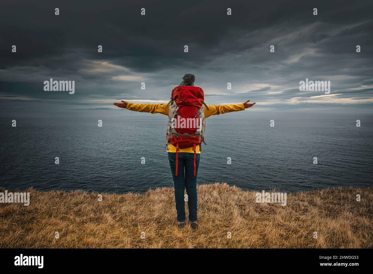 Female backpacker traveller in Iceland watching the Ocean Stock Photo ...