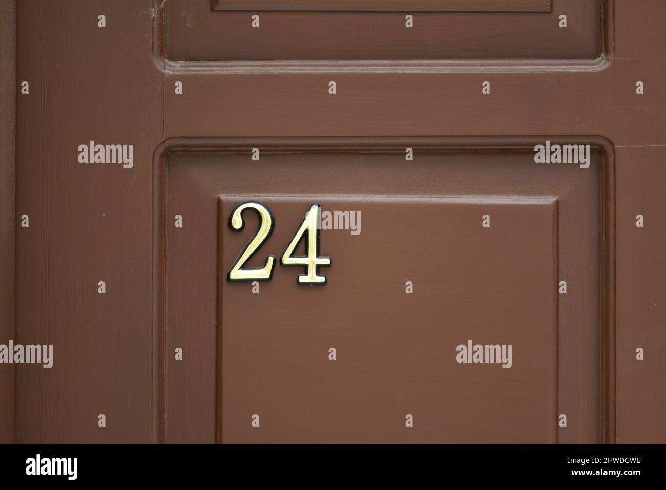 Traditional house wooden door with an antique brass street number in ...