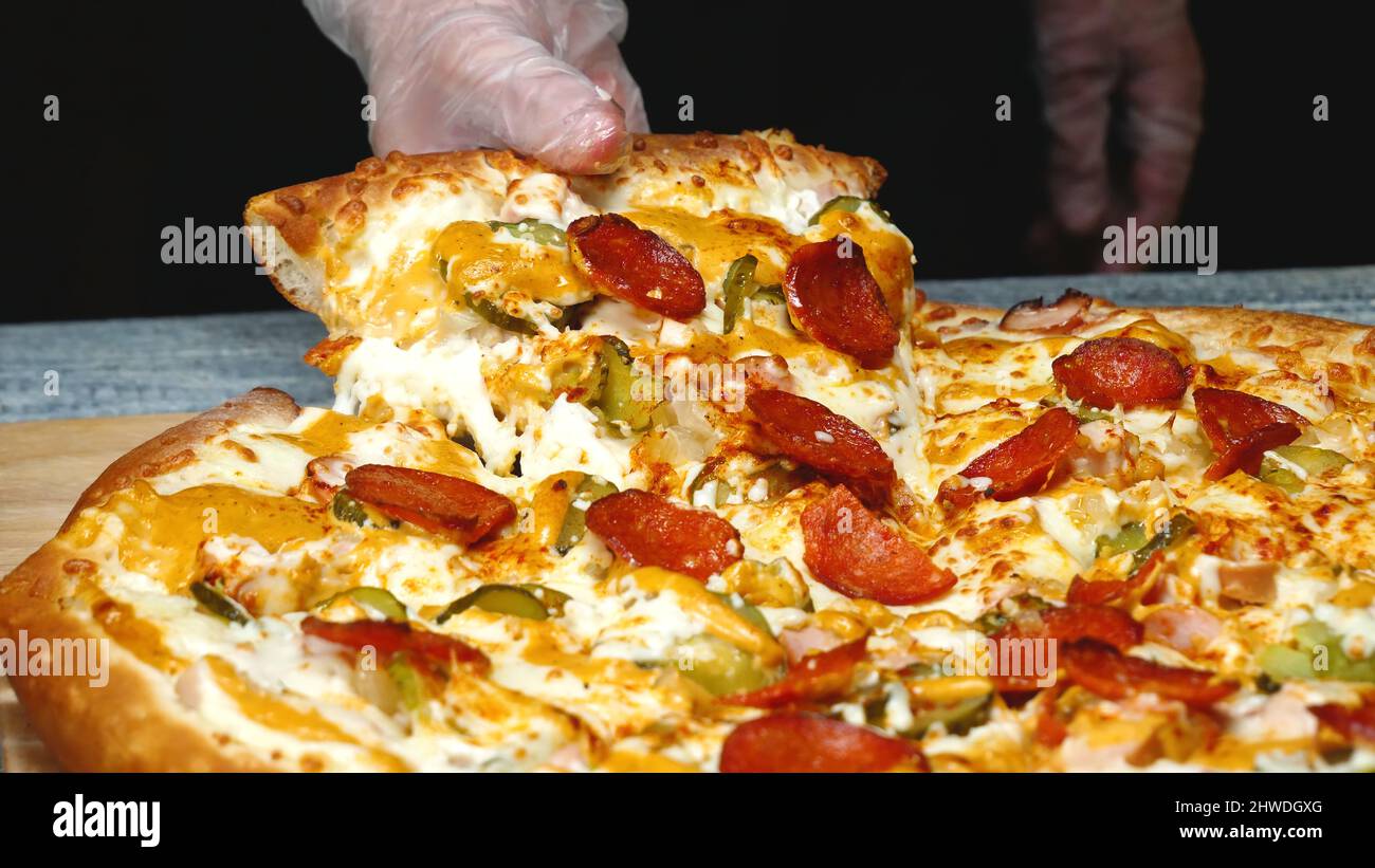 Close-up of man takes delicious slice of pizza with cheese. Frame. Man ...
