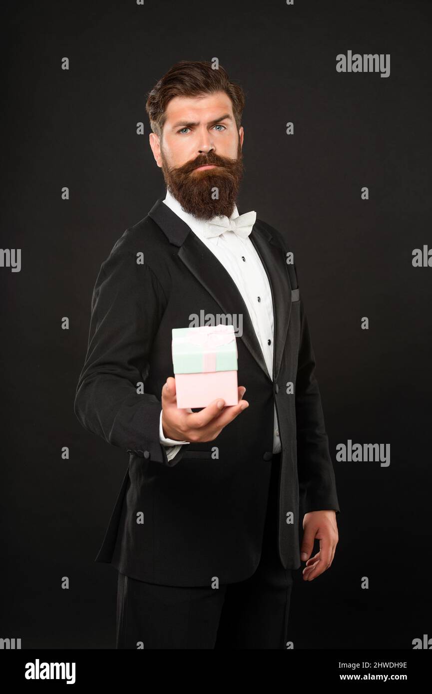 bearded man in tuxedo bow tie formalwear on black background with box ...