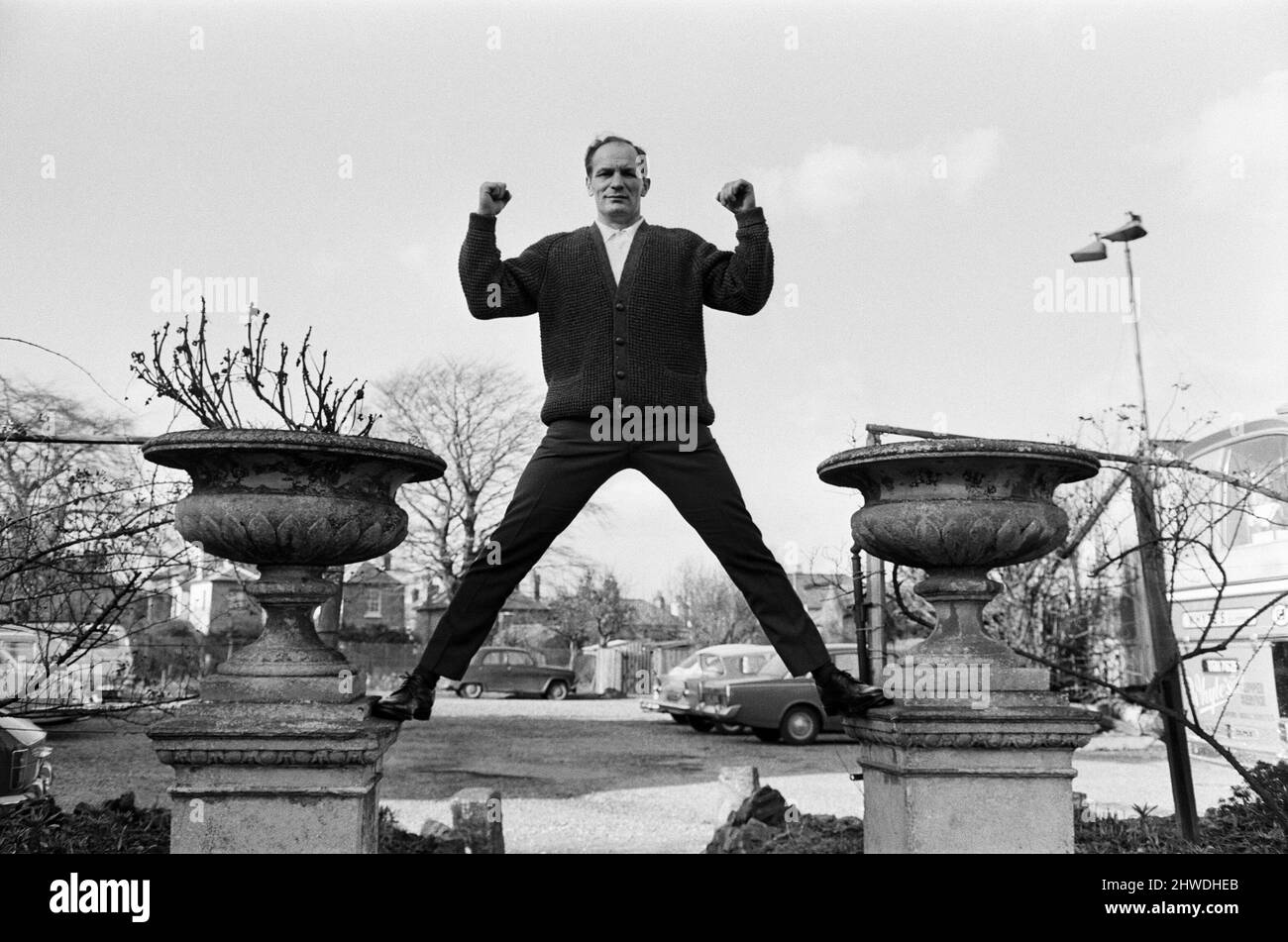 Henry Cooper, pictured standing astride two ornamental flower pots in ...