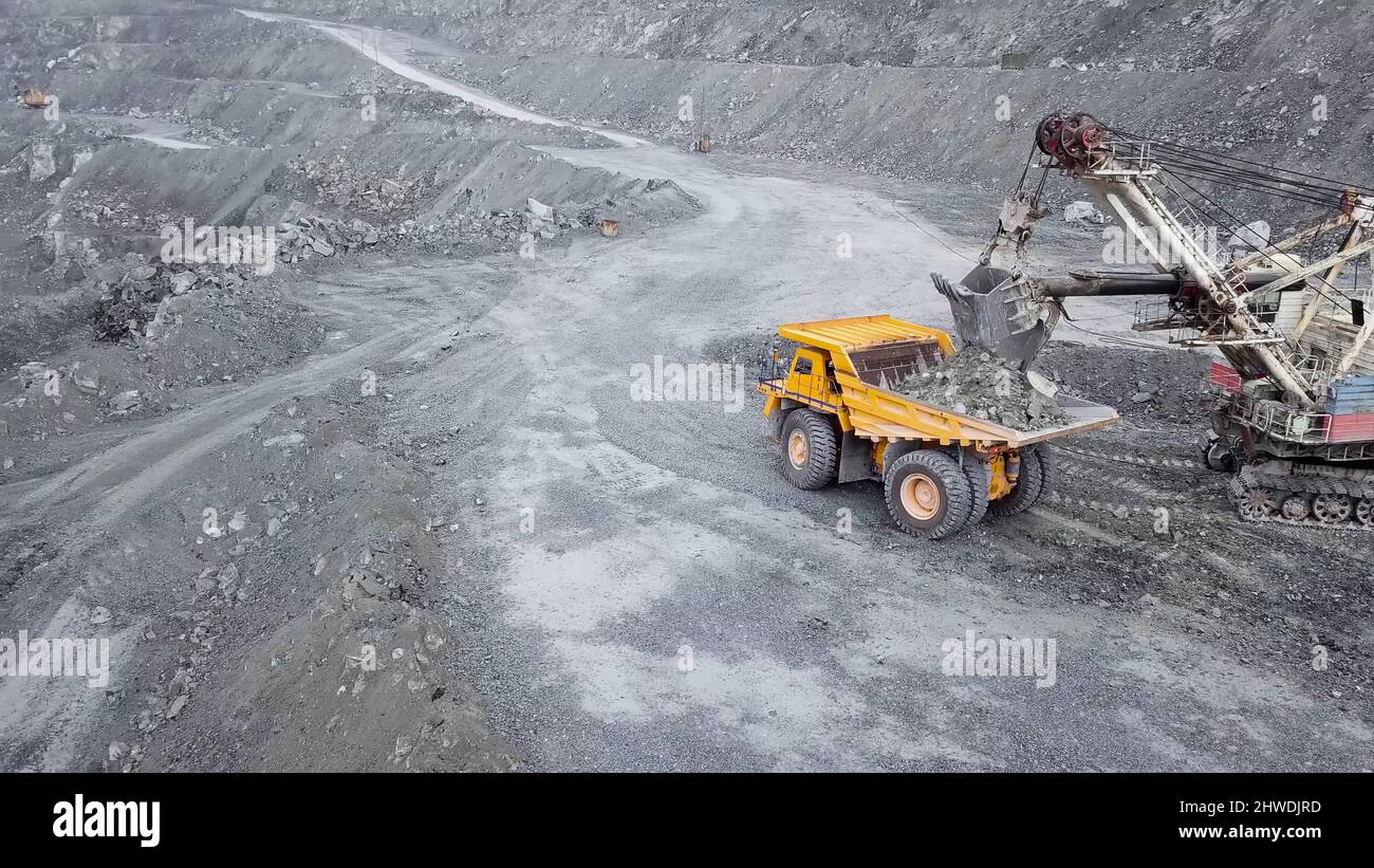 Top view of excavator in open pit. Excavator falls asleep rubble in ...